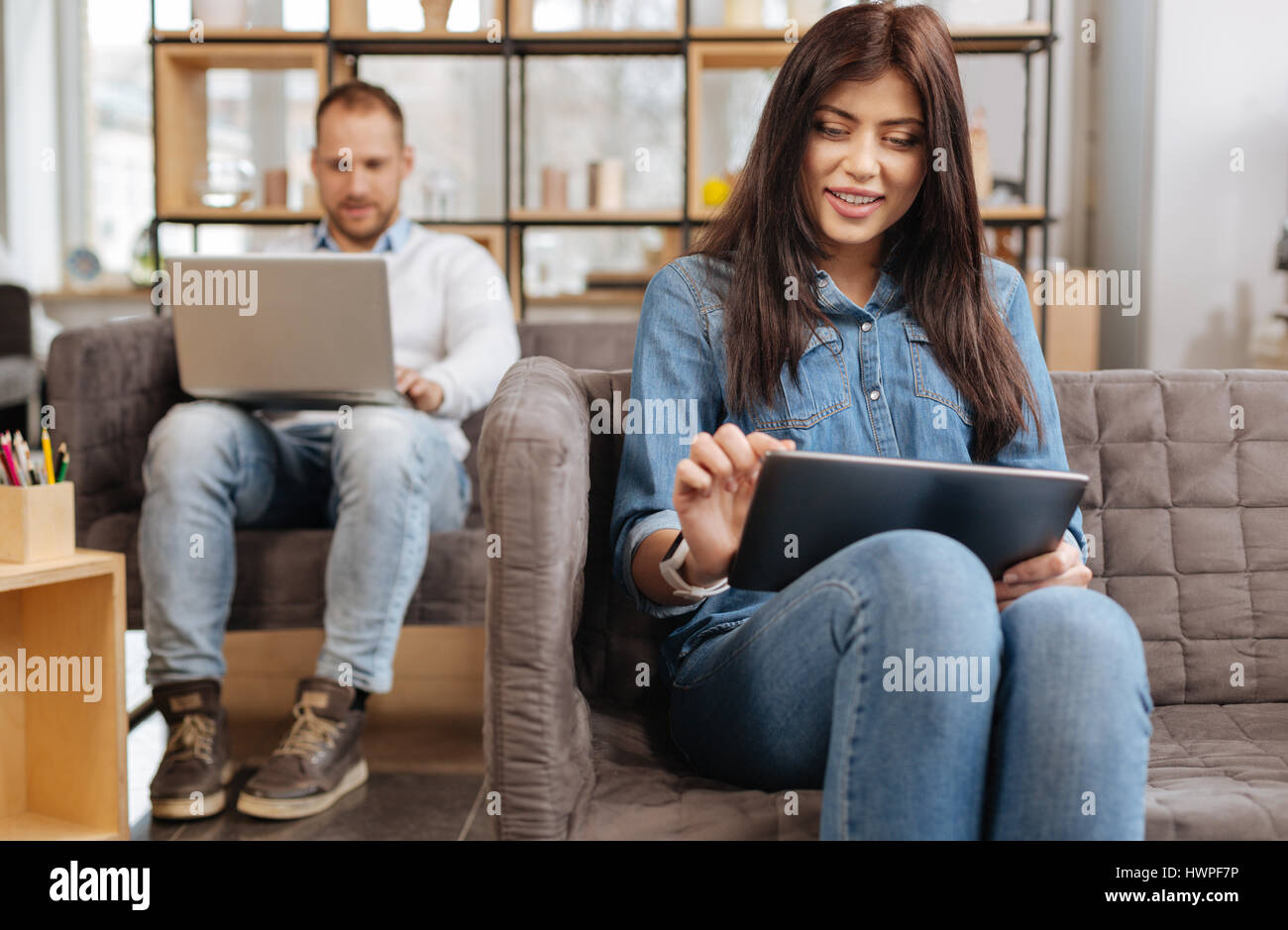 Positive nice woman sitting on the couch Stock Photo - Alamy