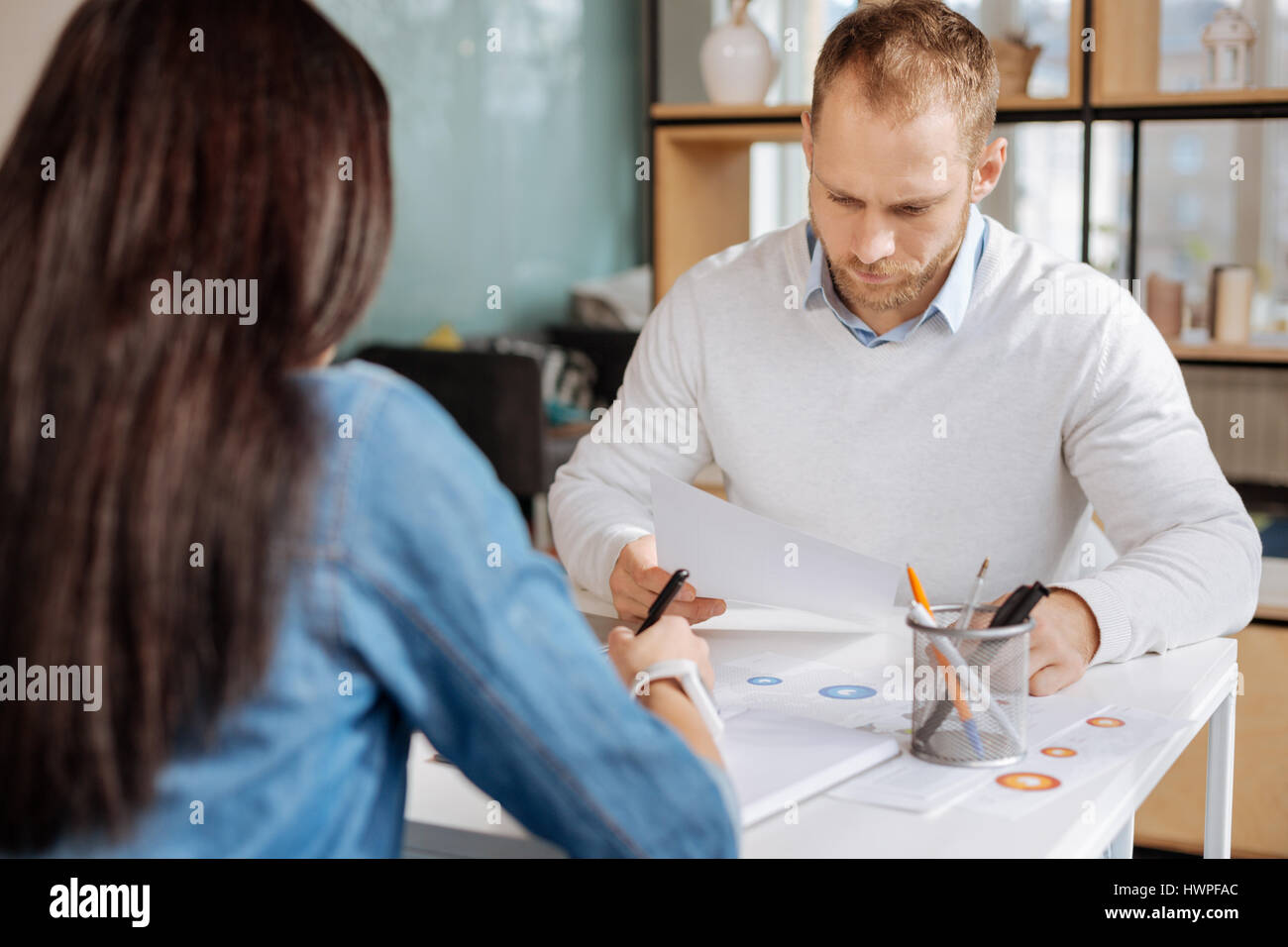 Serious concentrated man looking at the sheet of paper Stock Photo - Alamy