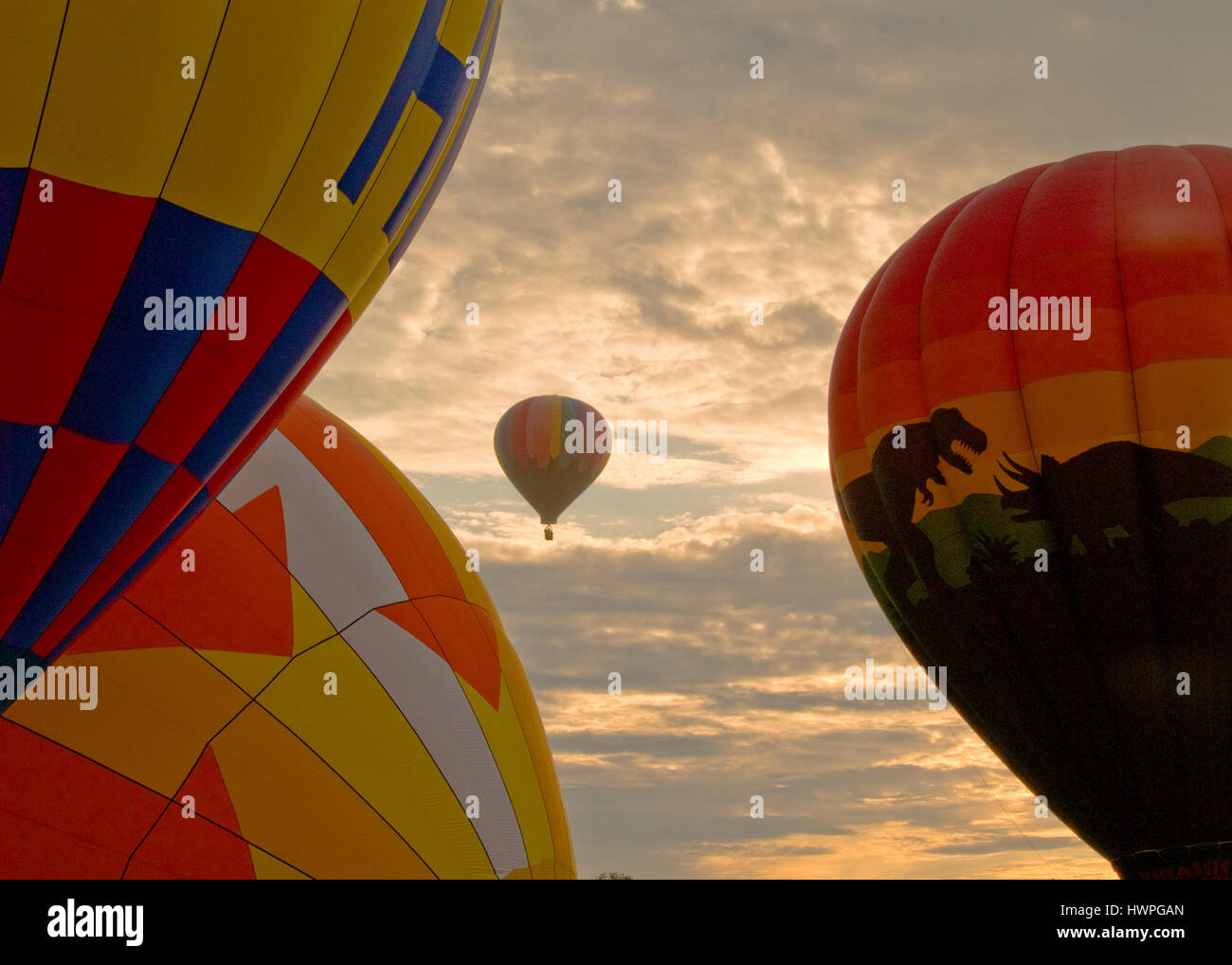 Four hot air balloons take flight as the sun sets in a golden sky Stock ...