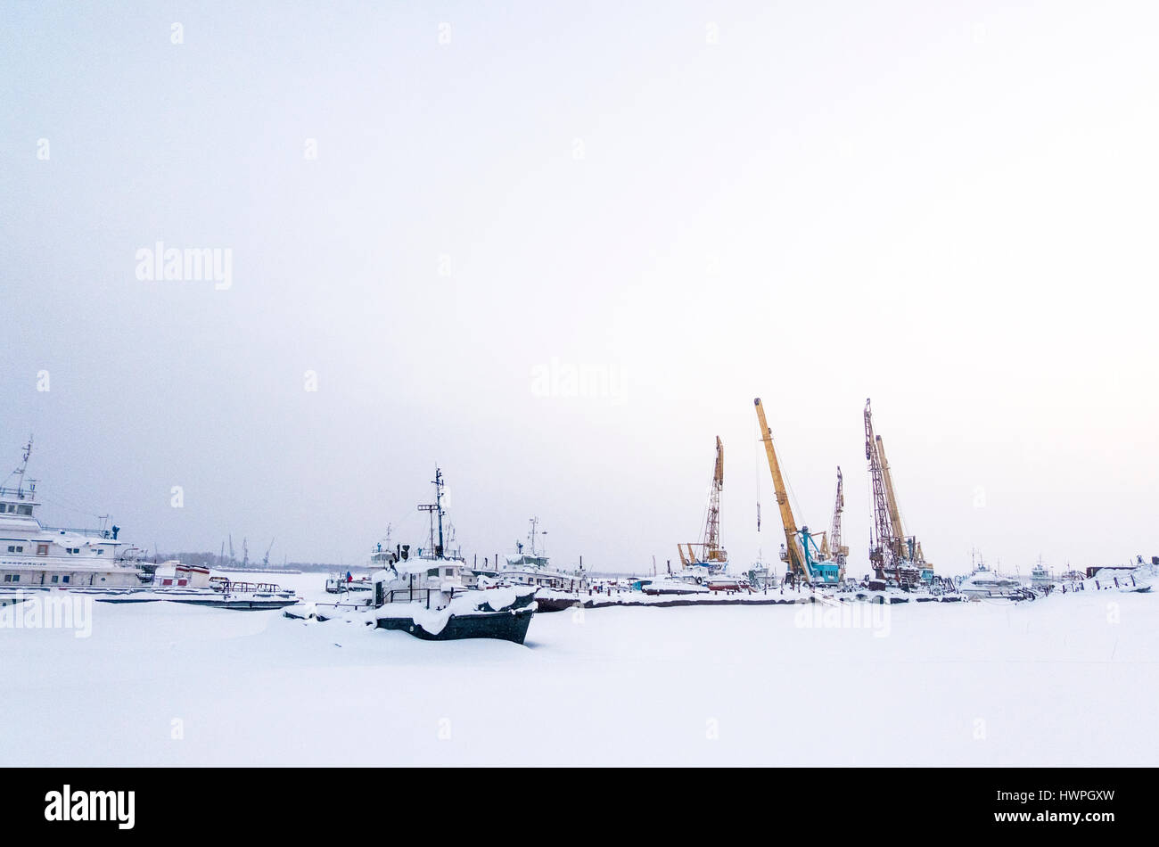 Boats moored at snow covered harbor against sky Stock Photo - Alamy