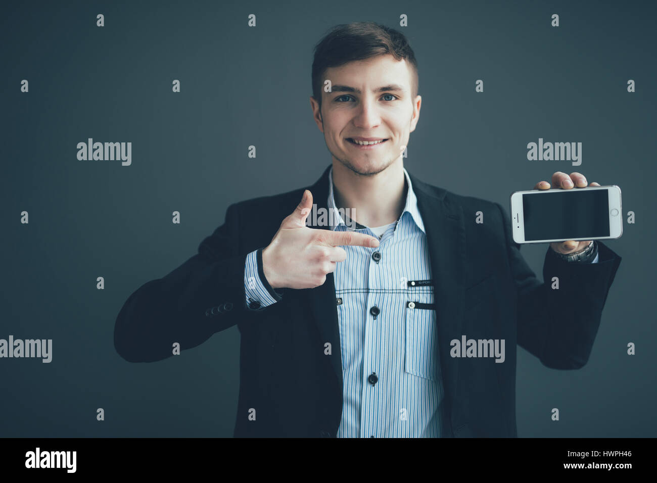 Cheerful businessman pointing smartphone hi-res stock photography and ...