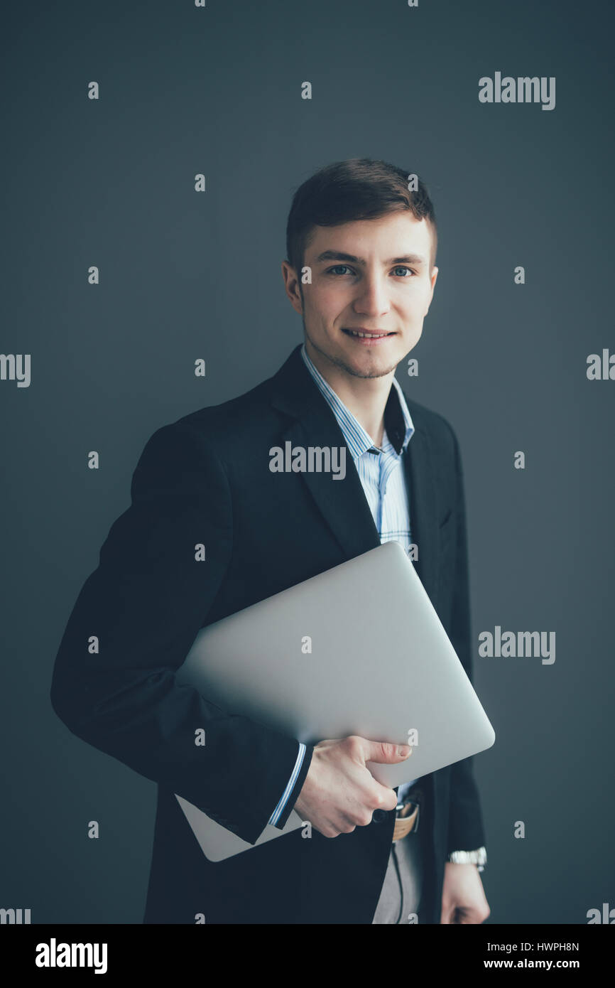 Man standing on dark background with laptop Stock Photo - Alamy