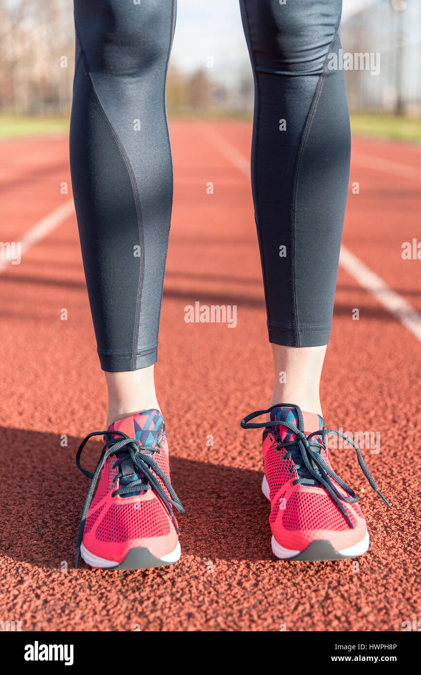 Low section of female athlete standing on sports track Stock Photo - Alamy