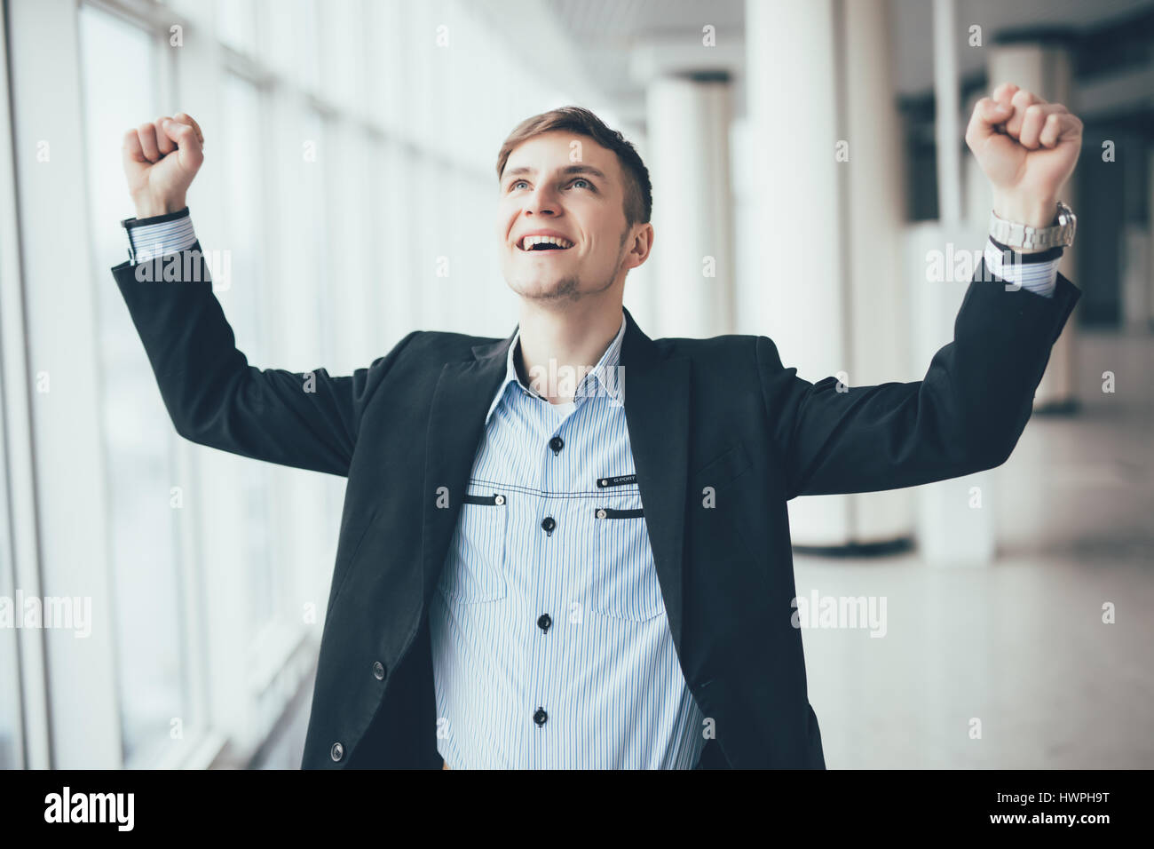 Business man with rised hands in his office Stock Photo - Alamy