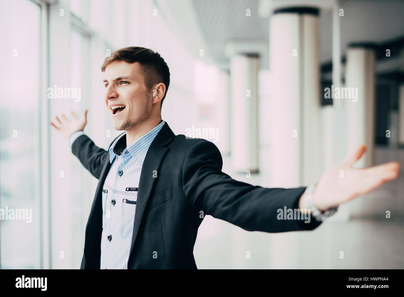 Business man with rised hands in his office Stock Photo - Alamy