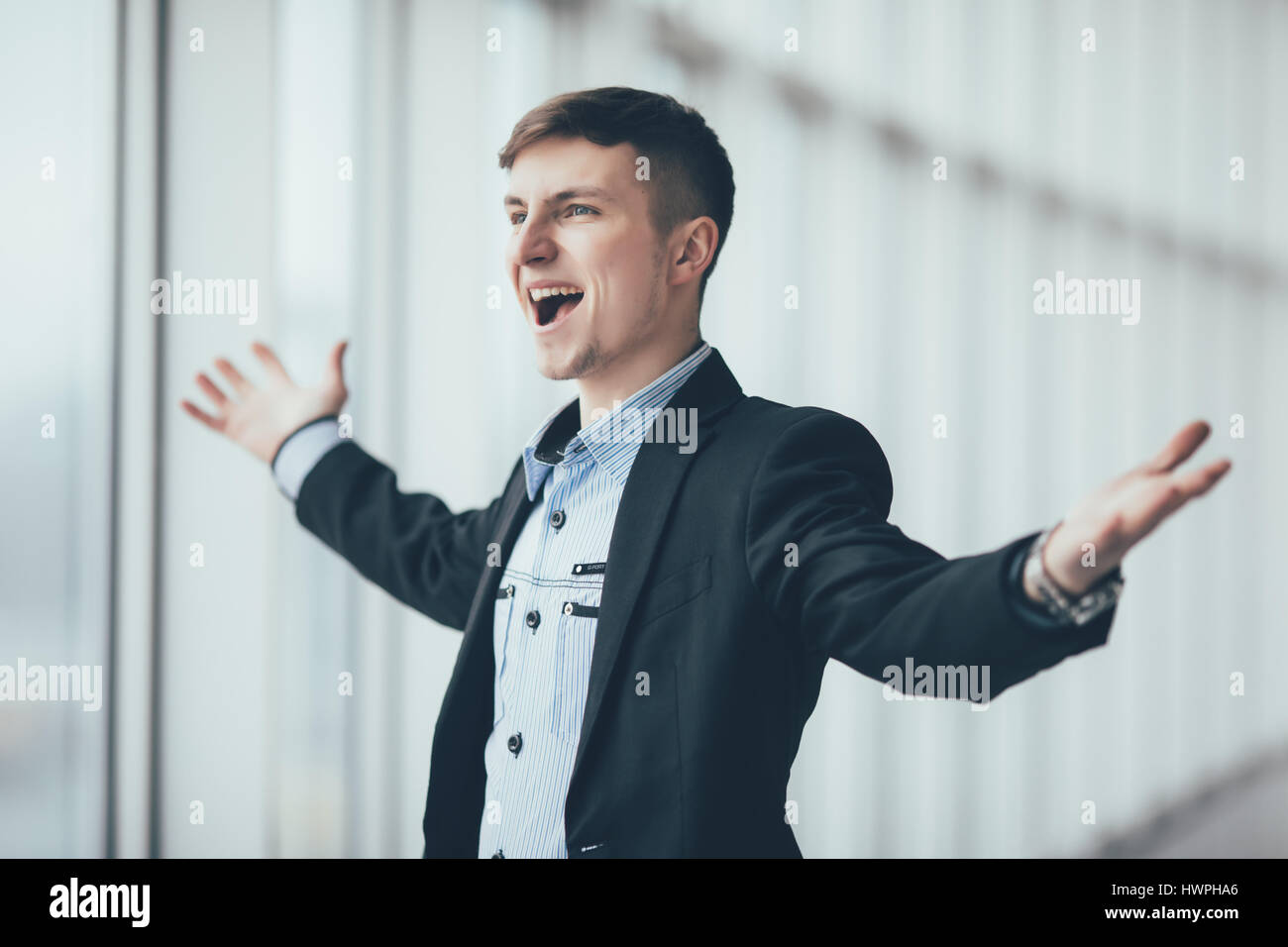 Business man with rised hands in his office Stock Photo - Alamy