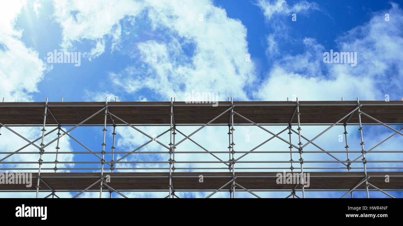 3d image of construction scaffolding against bright blue sky with ...