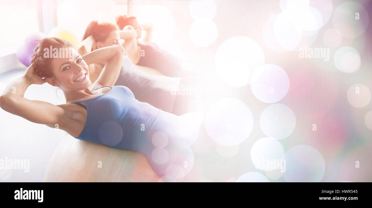 Side view of women doing situps on exercise balls at gym Stock Photo ...