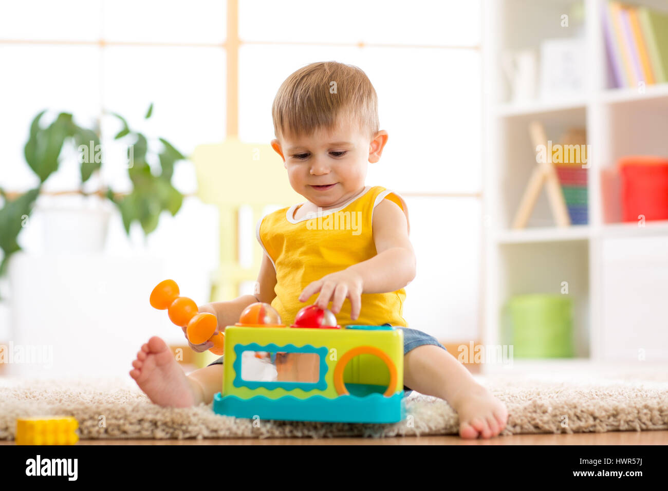Funny baby boy studying nursery room Stock Photo - Alamy