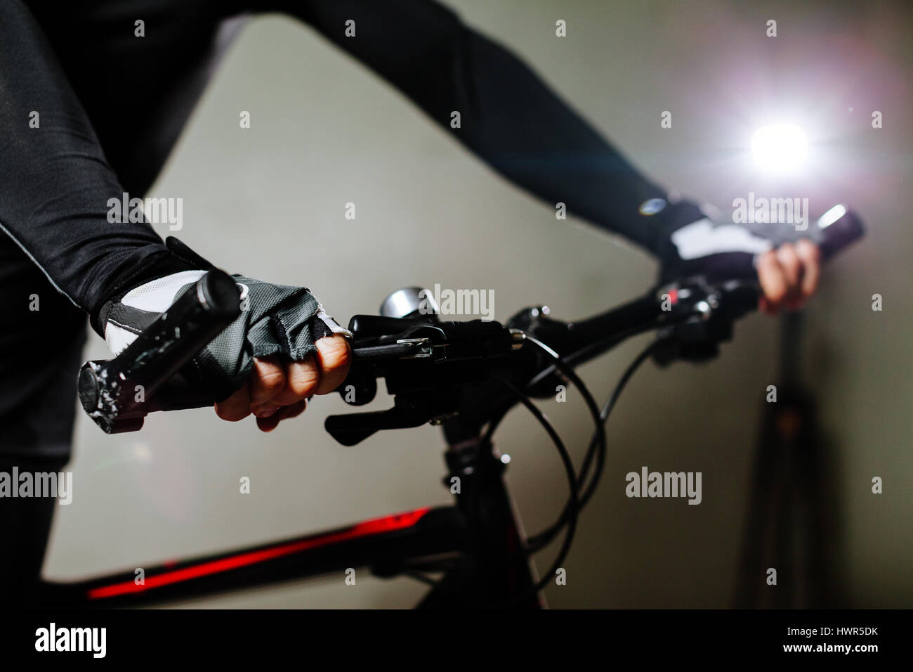 cycle man with bike indoors. Man in black cycling Apparel on gray wall ...
