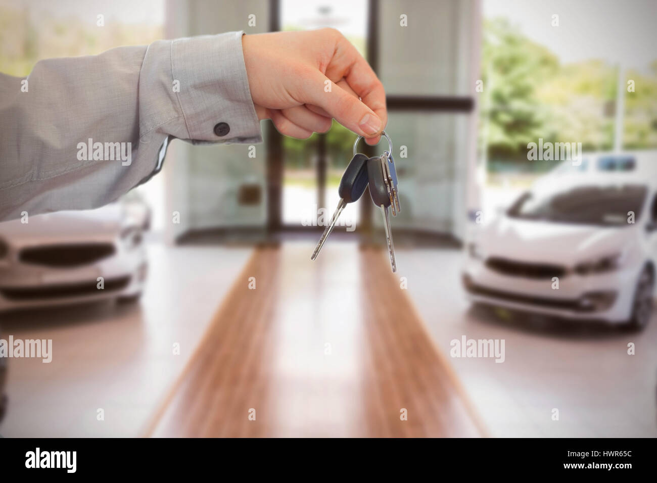 Man giving keys to someone against white cars parked Stock Photo - Alamy