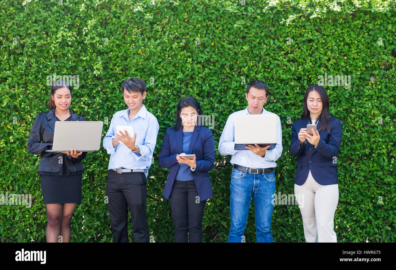 Businesswoman and businessman working outside office using laptop ...