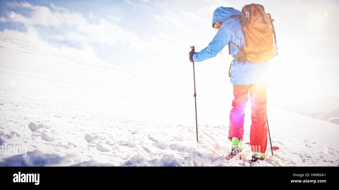 Full length rear view of skier walking on slope with ski Stock Photo ...