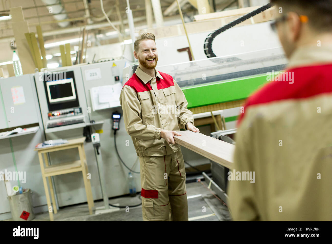 Two young men working in the furniture factory Stock Photo - Alamy