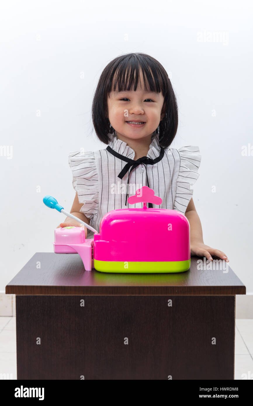 Happy Asian Chinese little girl pretending as cashier with toys in ...