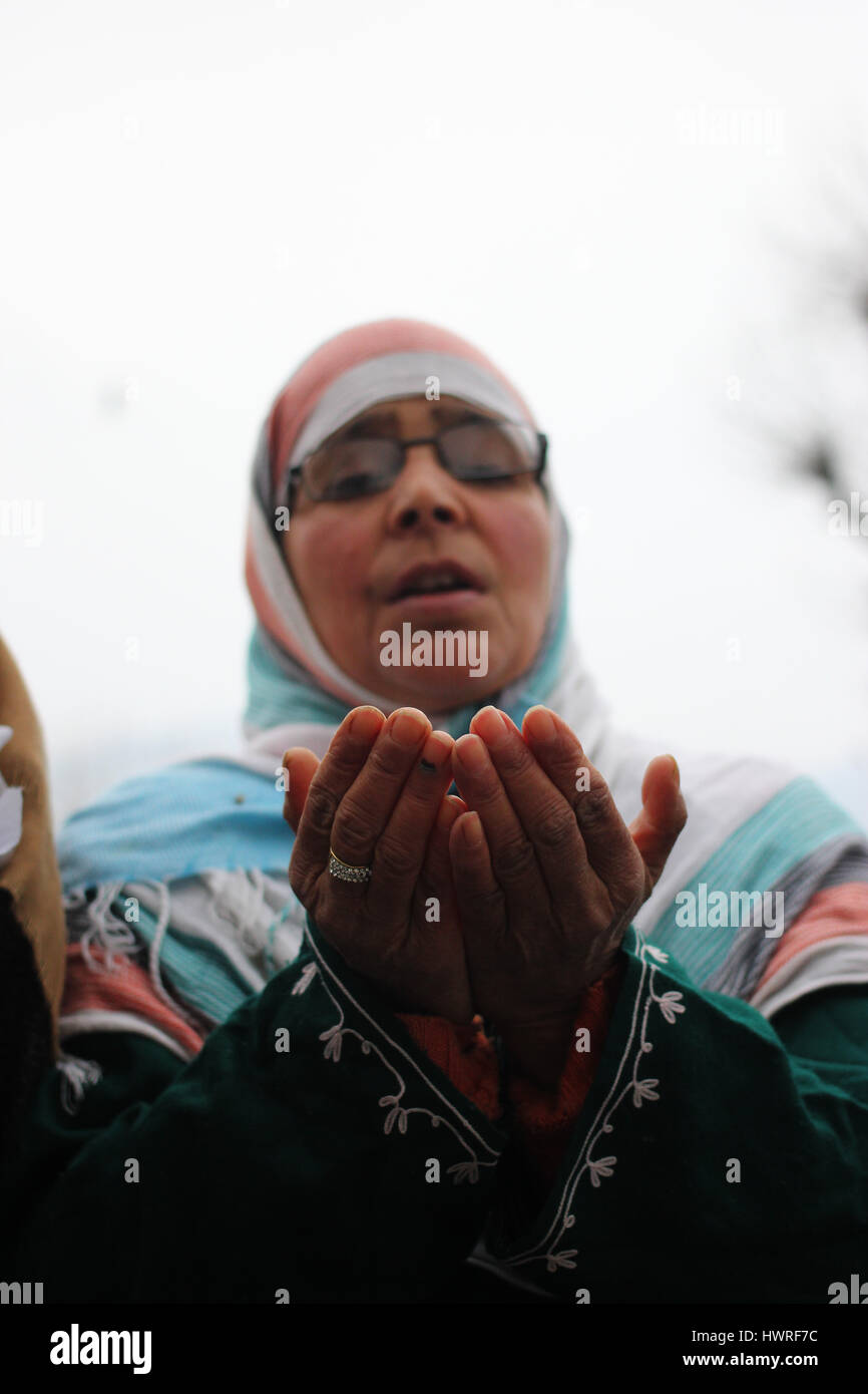 Srinagar, India. 22nd Mar, 2017. A Woman raise hands towards the holy ...