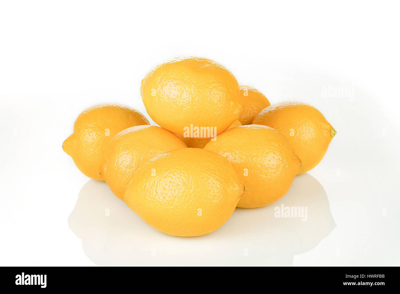 Bright yellow lemons on a white surface. Isolated on white background ...