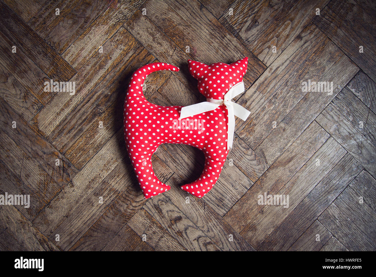 horizontal top view of red homemade children cloth cat toy with polka ...