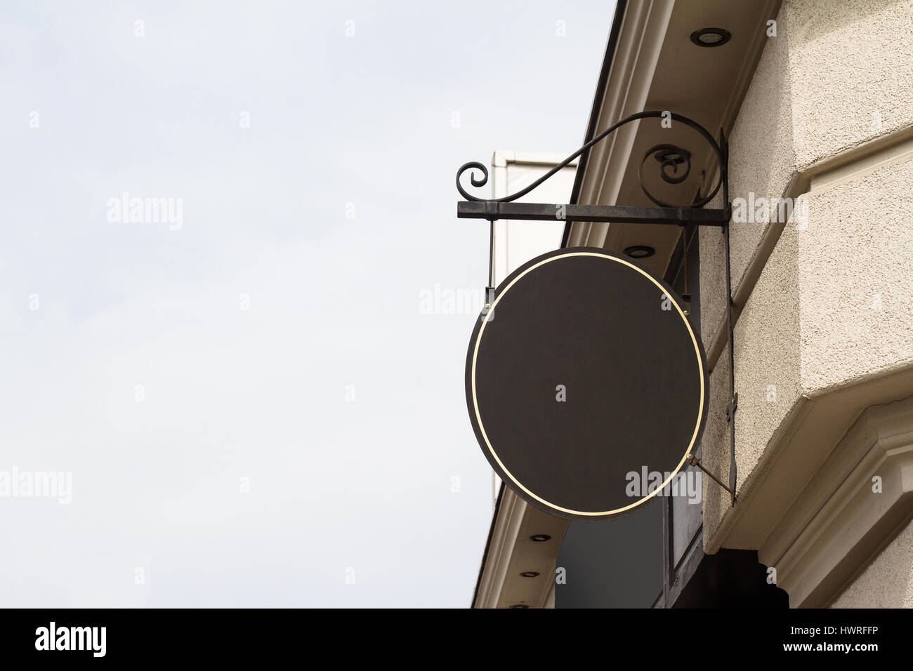 Horizontal front view of black empty round signage on a building with ...