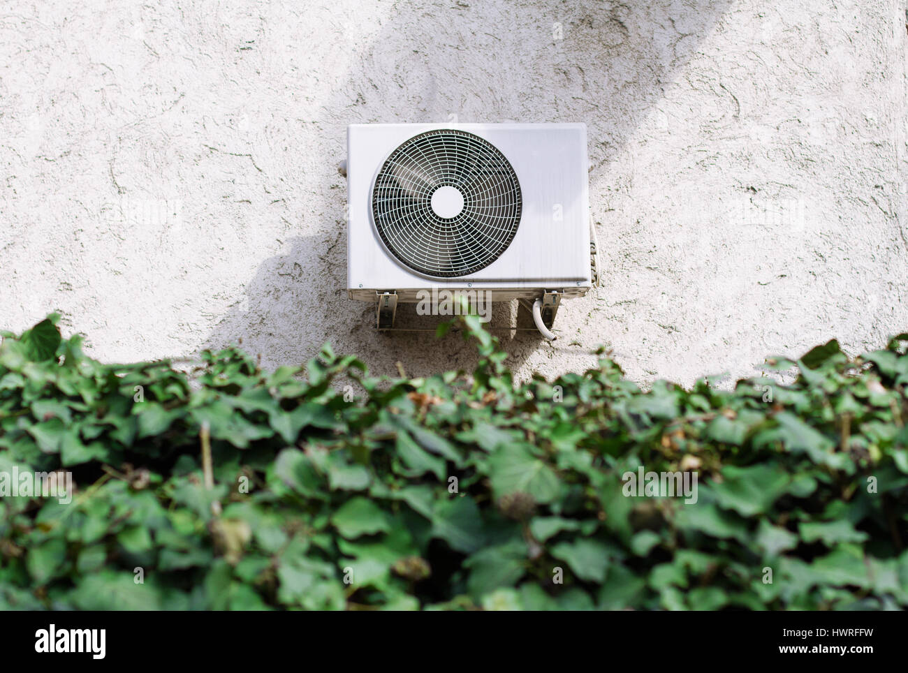 horizontal front view of a white air conditioning unit behind a ...