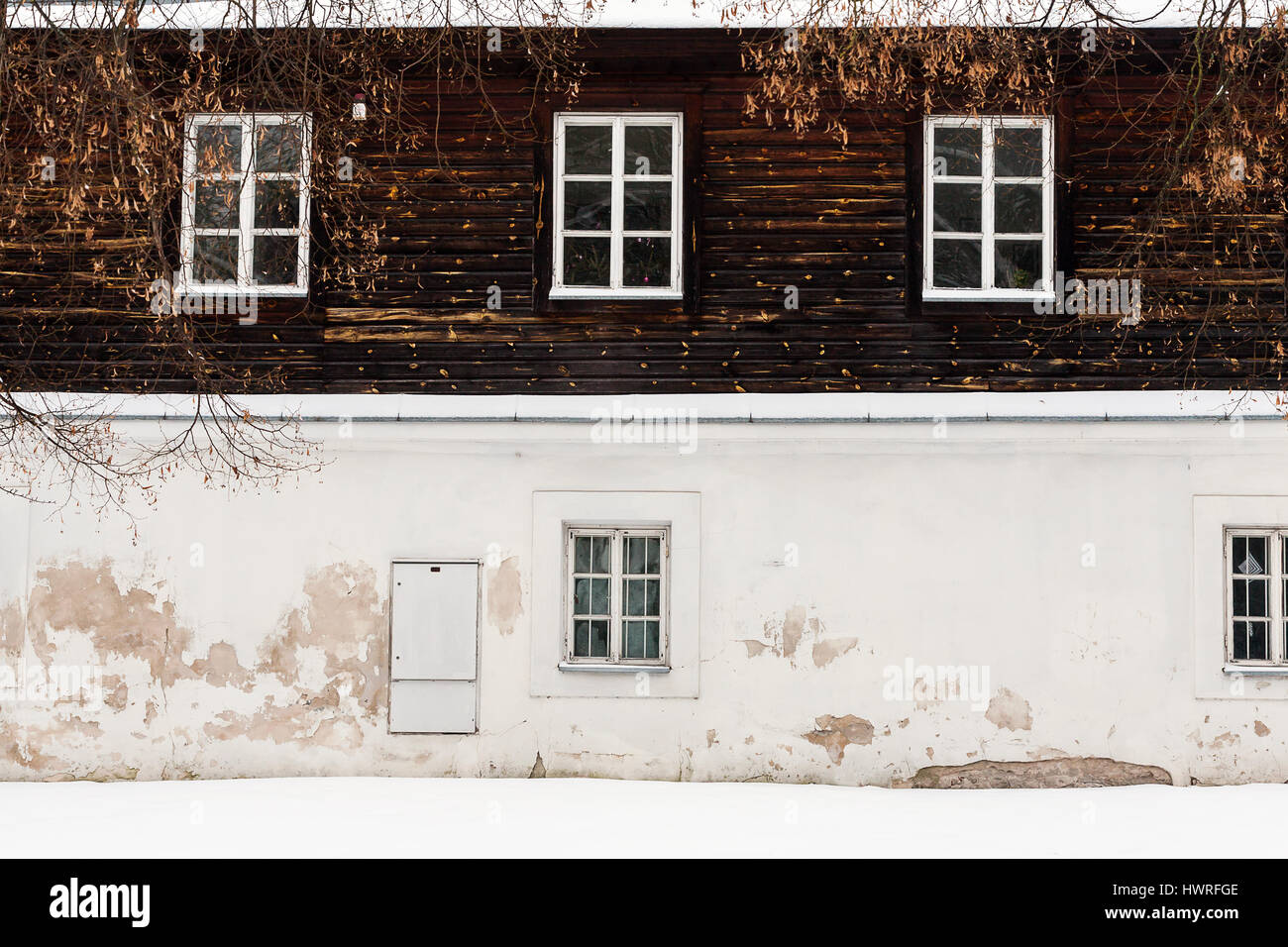 Old building in winter season. Plaster and wood wall with some windows ...