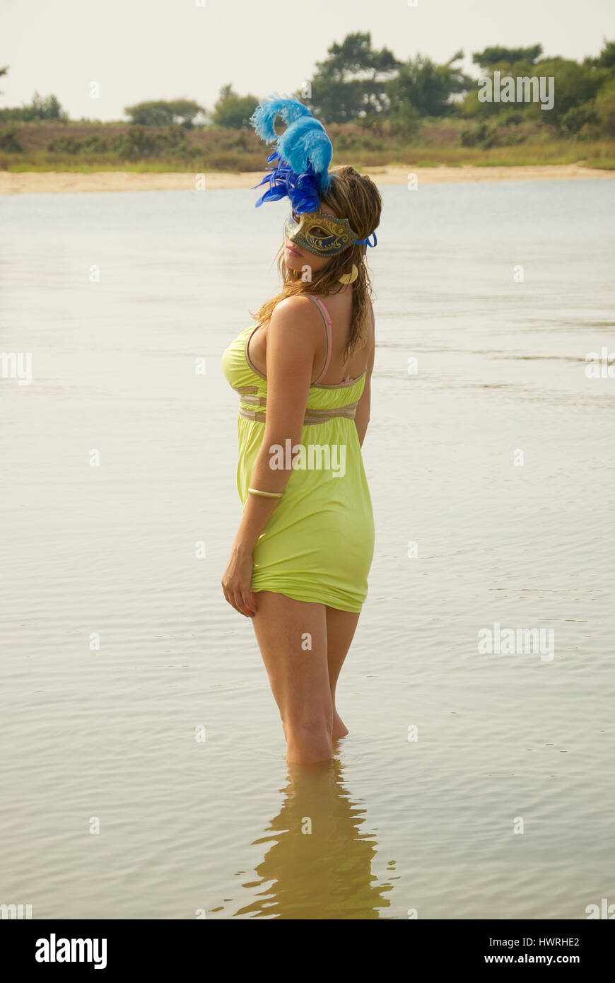 Beautiful young woman on the beach wearing a mask Stock Photo - Alamy