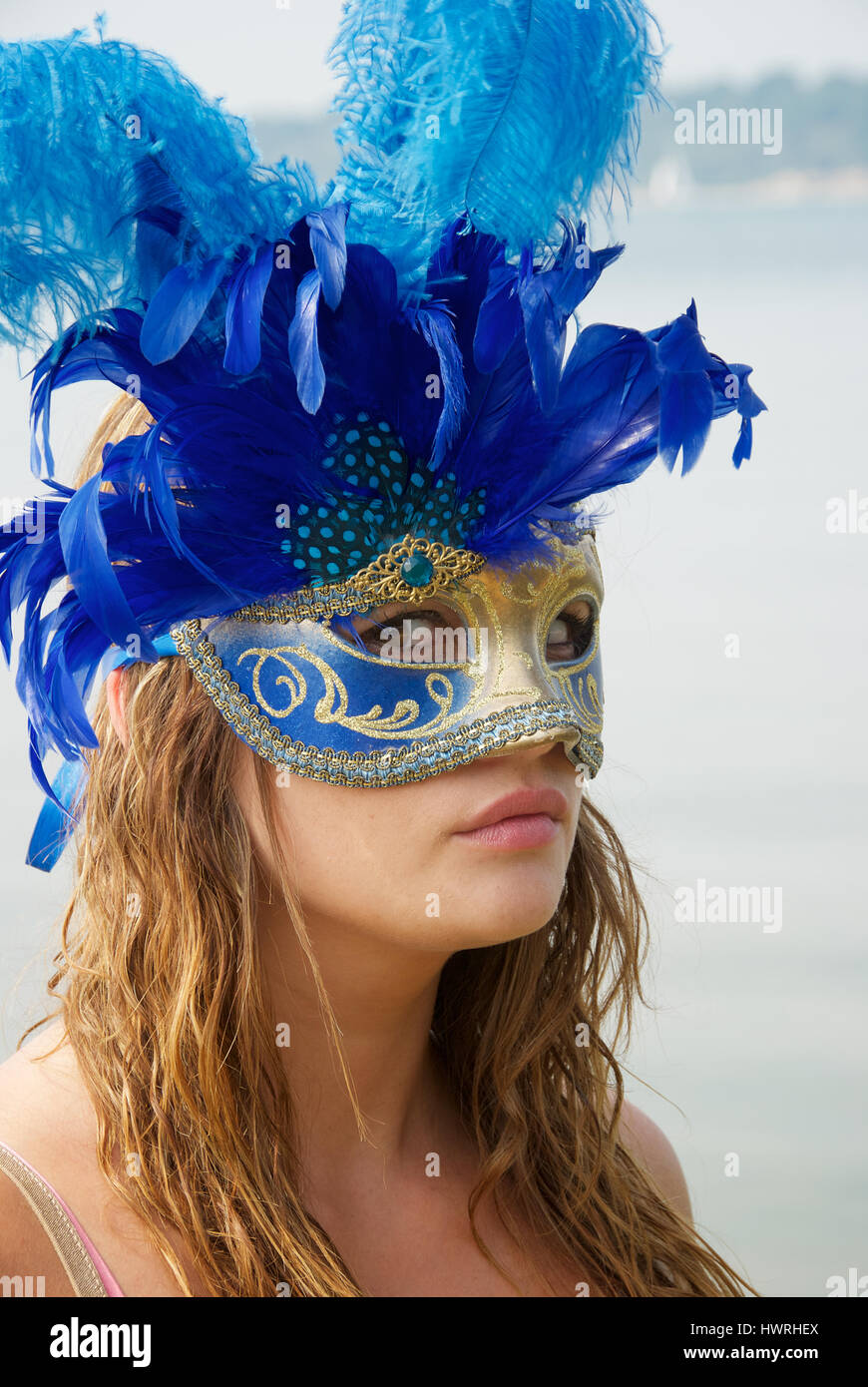 Beautiful young woman on the beach wearing a mask Stock Photo - Alamy