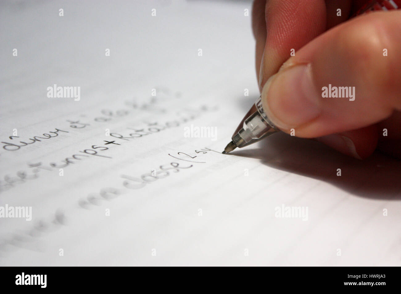 hand with a pencil writing on a piece of paper Stock Photo - Alamy