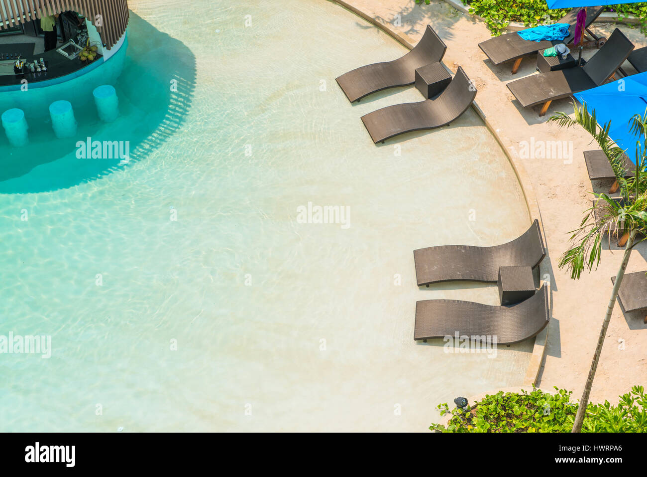 Beach chairs in luxury swimming pool at tropical hotel resort, relaxing ...