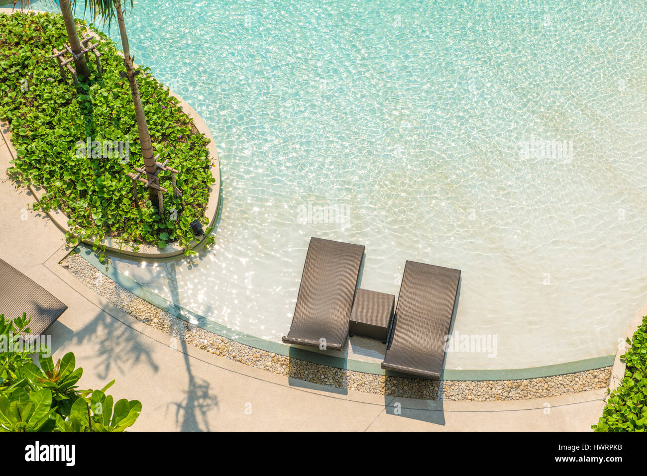 Beach chairs in luxury swimming pool at tropical hotel resort, relaxing ...