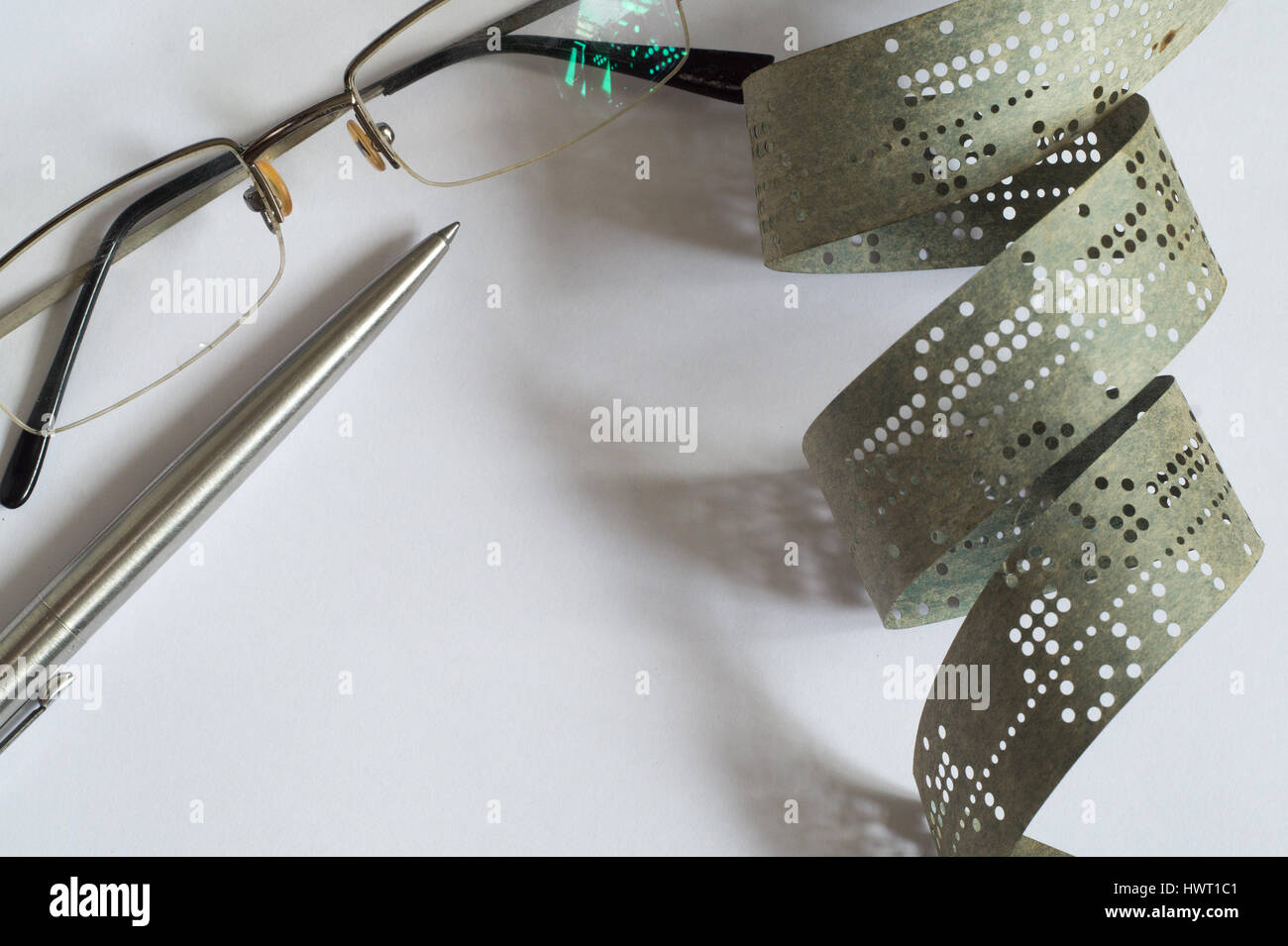 Strips of old punched tape on white surface Stock Photo - Alamy