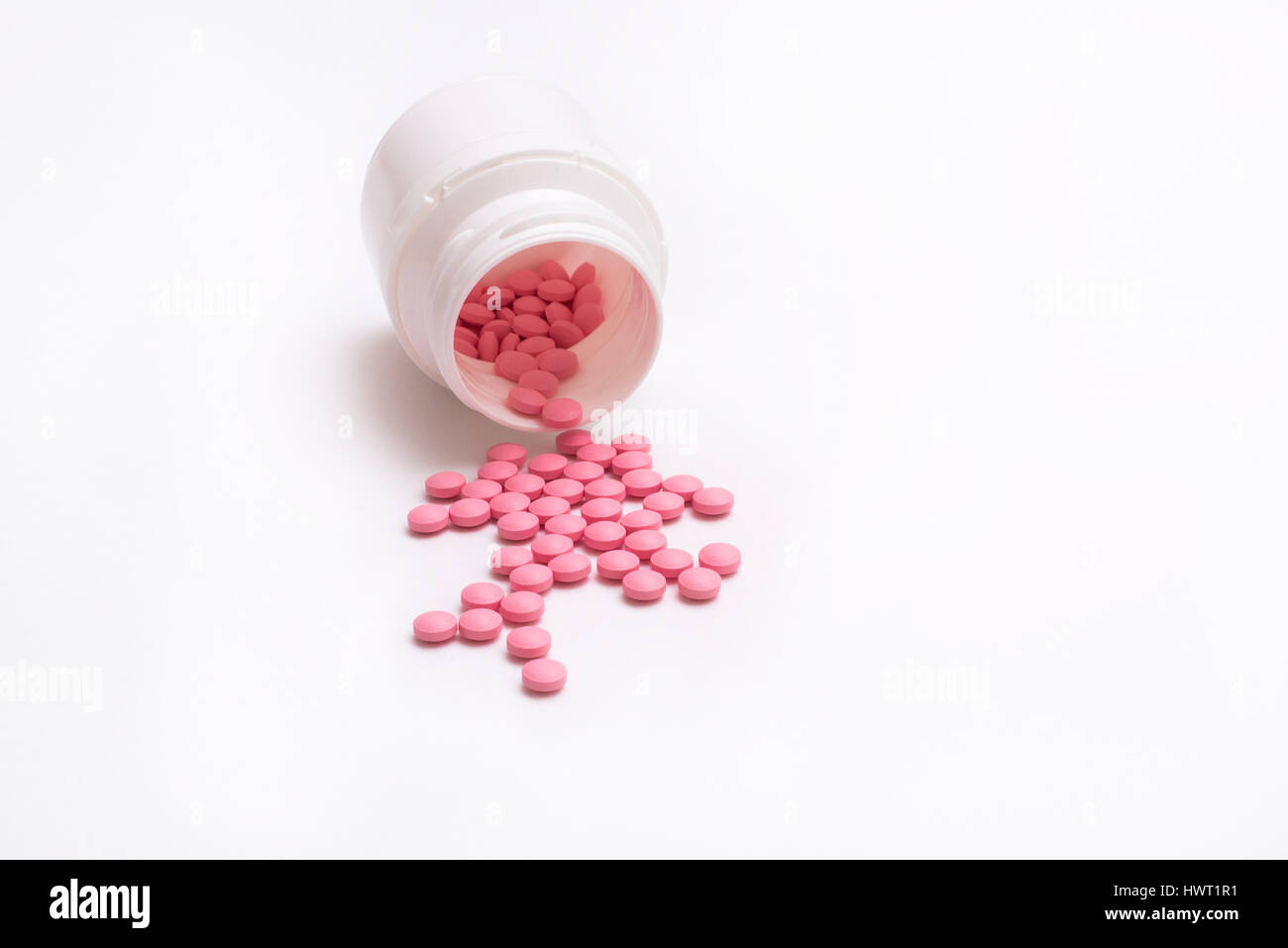 Pink pills spill out from bottle isolated on white background Stock ...