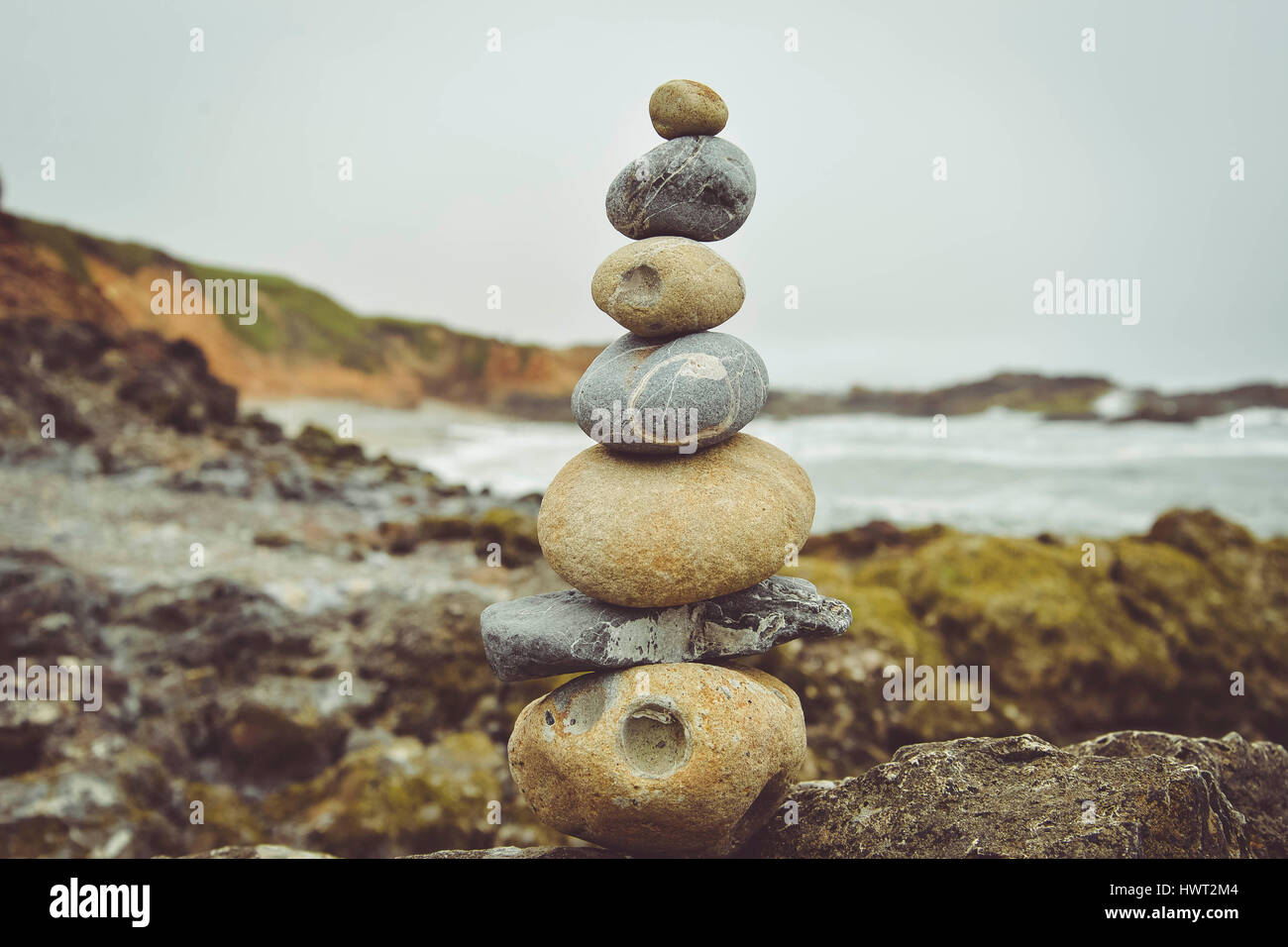 Stacked stones on rocks at beach against sky Stock Photo - Alamy