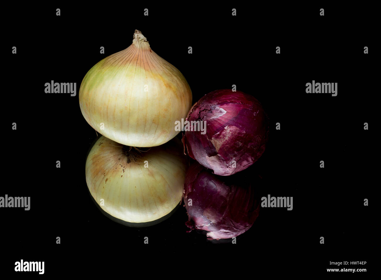 yellow and red onion on black reflective table Stock Photo - Alamy