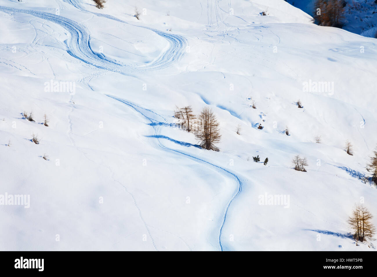 Skiers curves on the snowcapped mountains slopes Stock Photo - Alamy