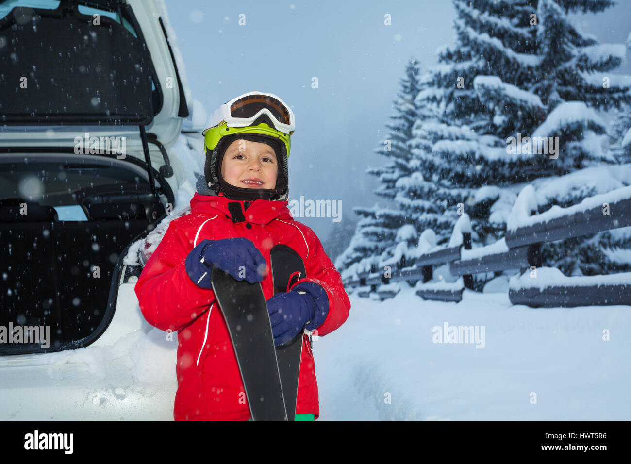 Happy little skier loading his skis in car trunk Stock Photo - Alamy