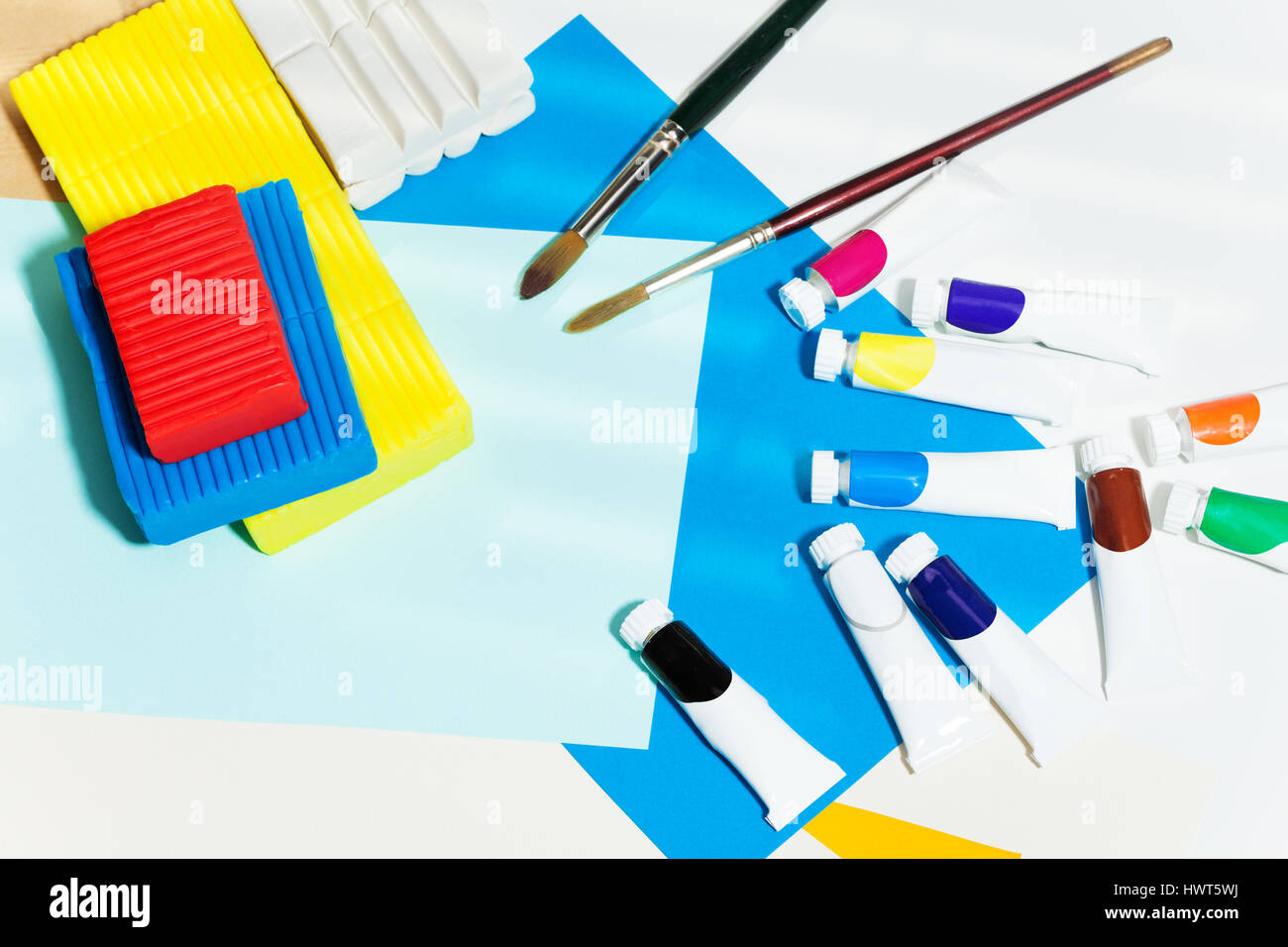 Brushes, tubes of paint and modeling clay on table Stock Photo - Alamy