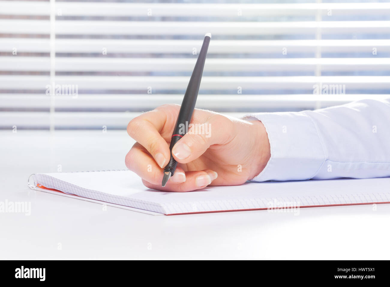 Hand making notes on the ring-bound notebook Stock Photo - Alamy