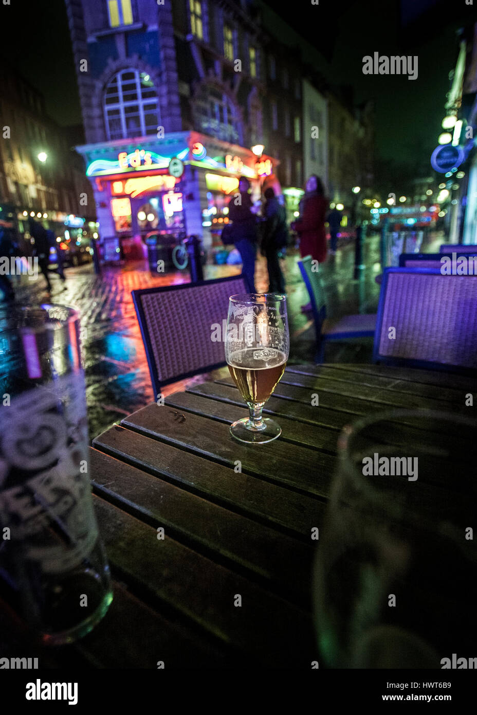 glass of beer table soho night rain reflections neon lights of Edds ...