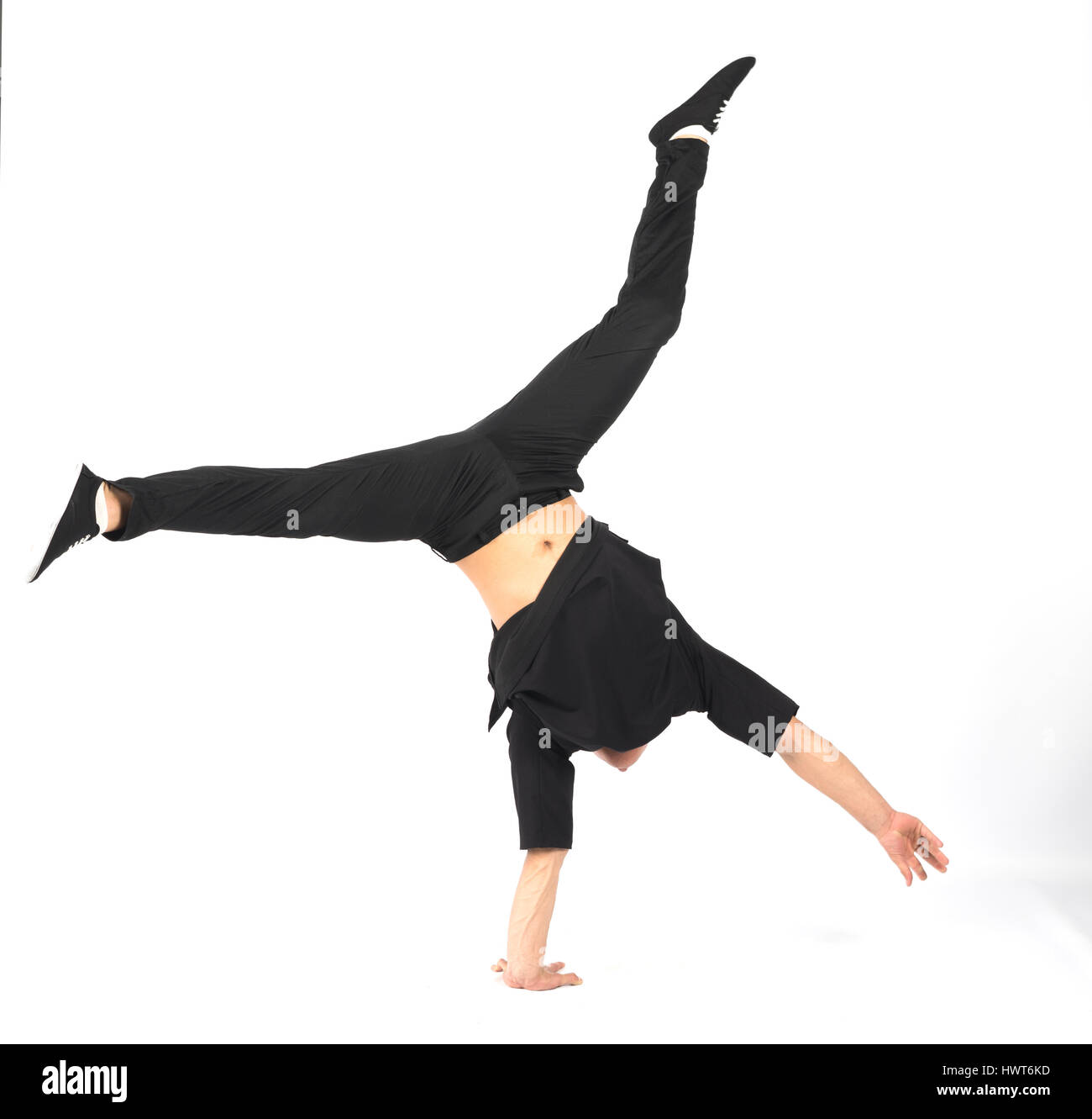 Young muscular breakdancer man stands on his hand He is wearing black ...