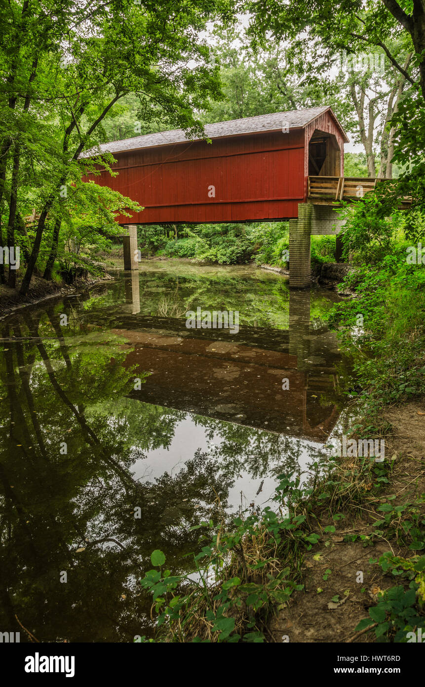 Historic Burr arch covered bridge reflects beautifully in peaceful ...