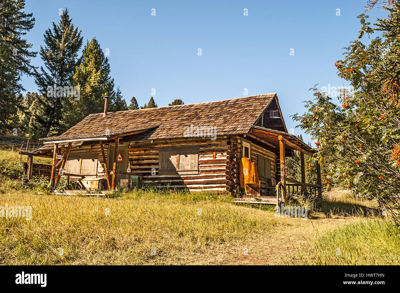 Good-sized abandoned log home with afternoon sunlight in a mining ghost ...