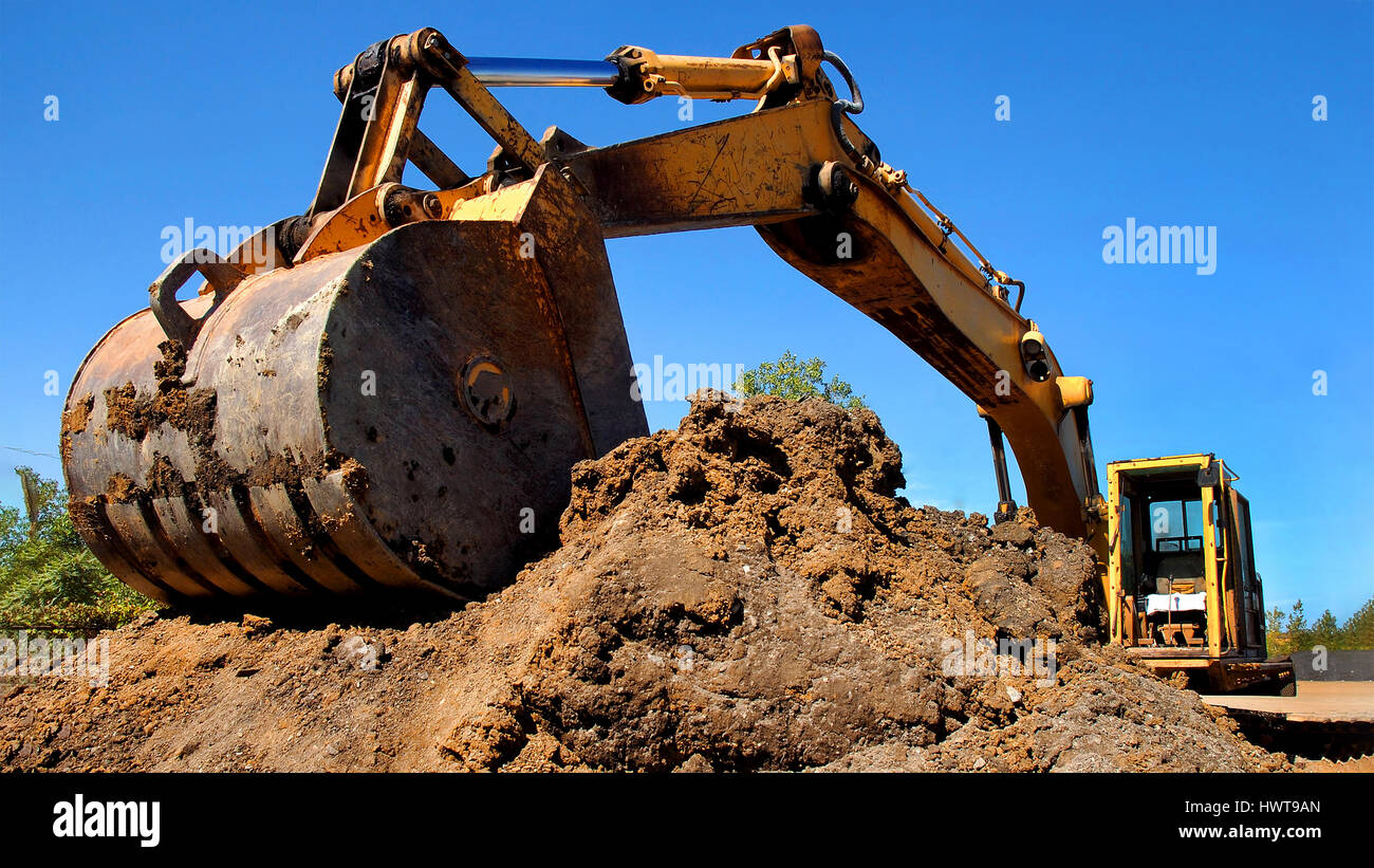 Crane digging foundation area for new construction Stock Photo - Alamy