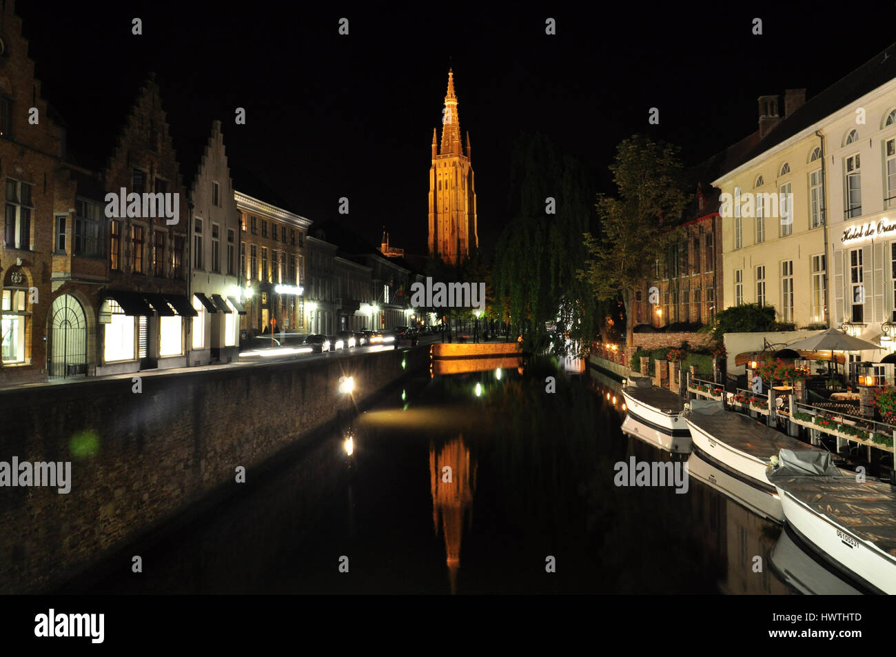Beautiful night Brugge view with canal reflections and white boats ...