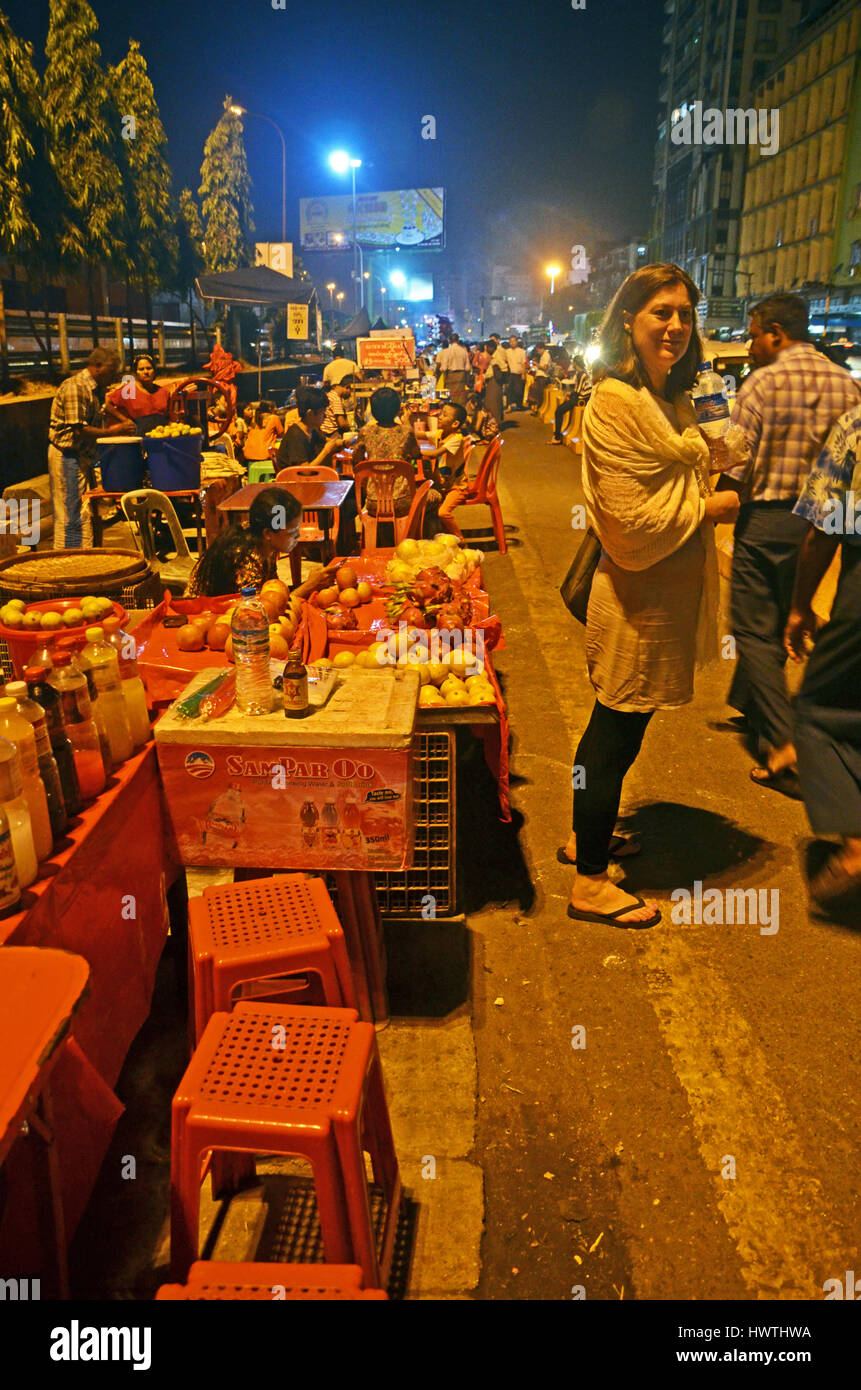 A tourist stands near a stall at the new night market in Yangon ...