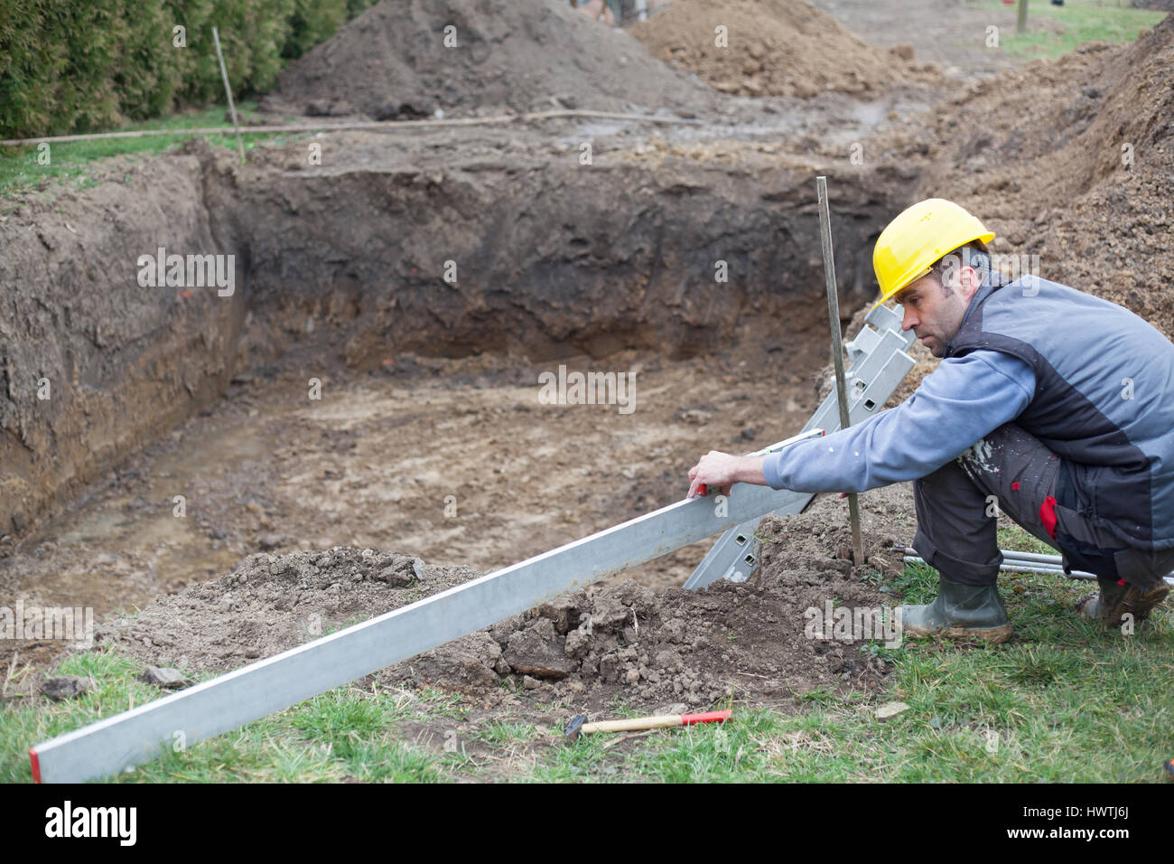 Man working on building a house with a private pool Stock Photo - Alamy