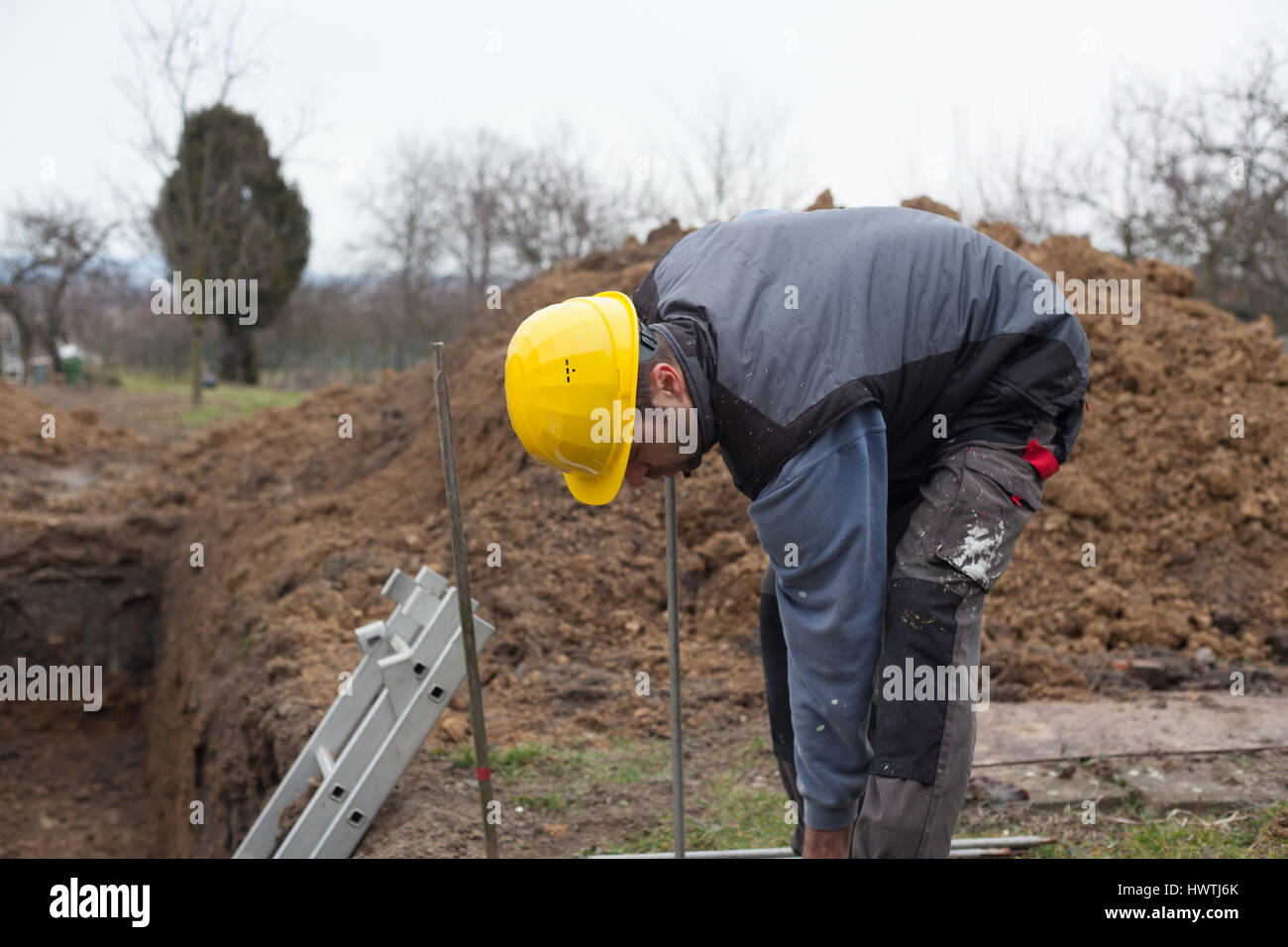 Man working on building a house with a private pool Stock Photo - Alamy