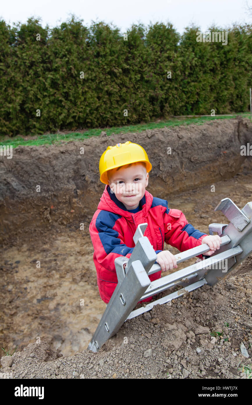 Little boy with a spade helps parents during the construction of the ...