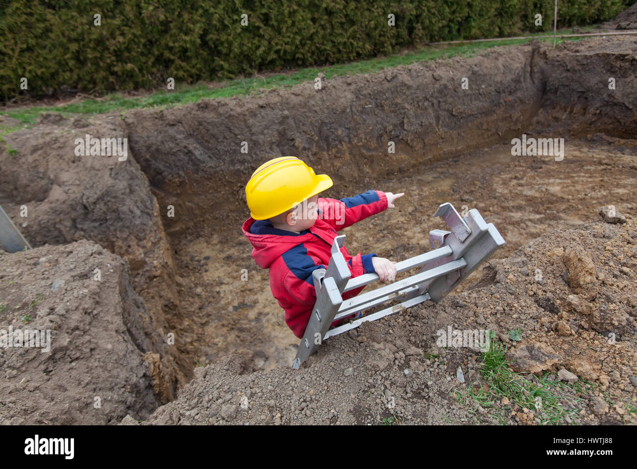 Little boy with a spade helps parents during the construction of the ...