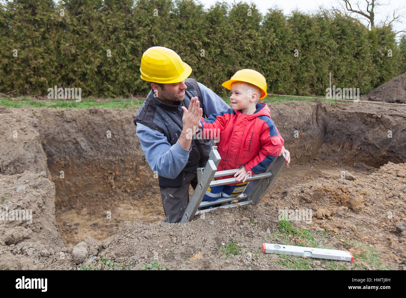 Father and son working on building a house Stock Photo - Alamy